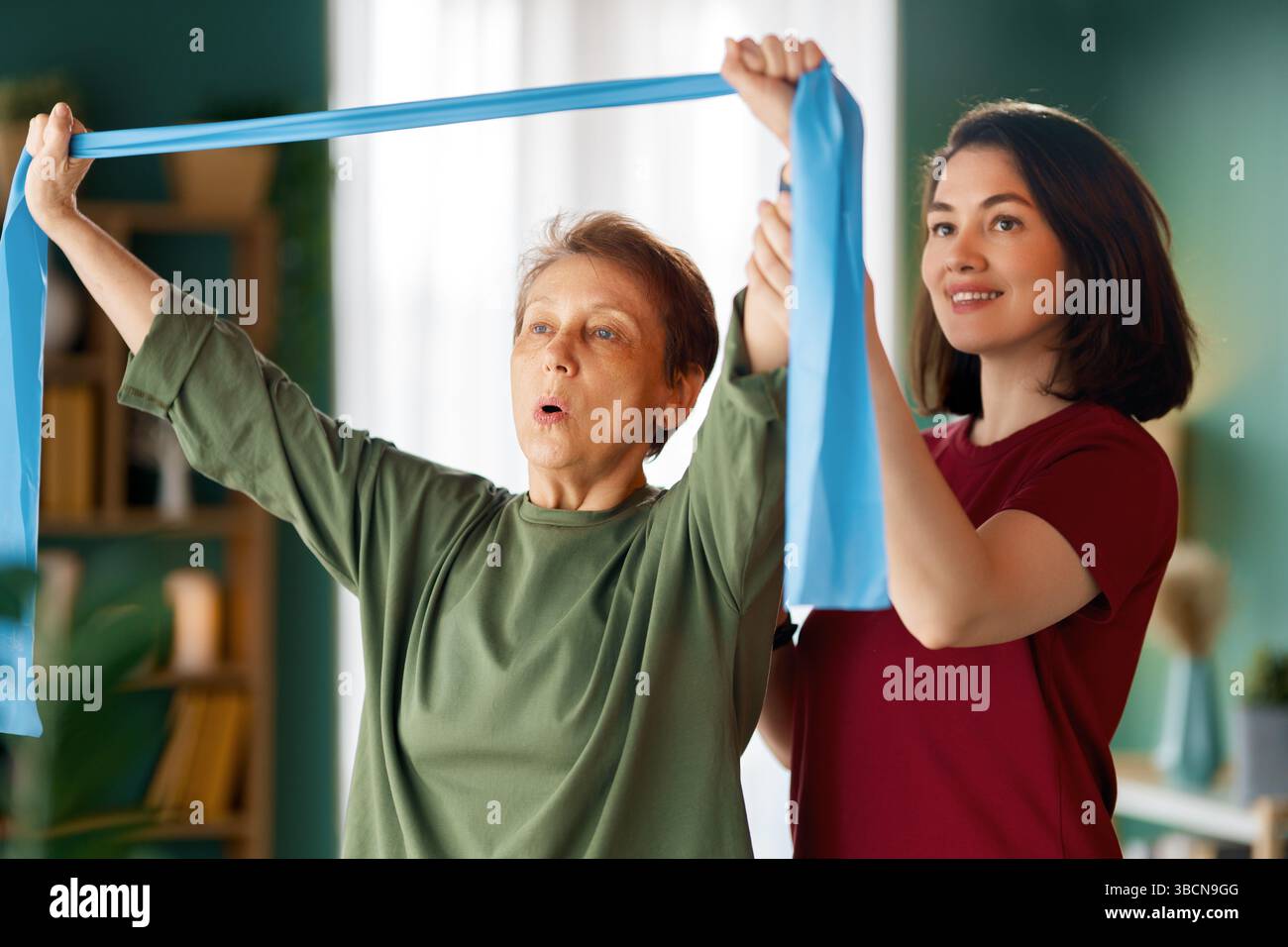 Senior woman doing exercise. A nurse helping with physical therapy at ...