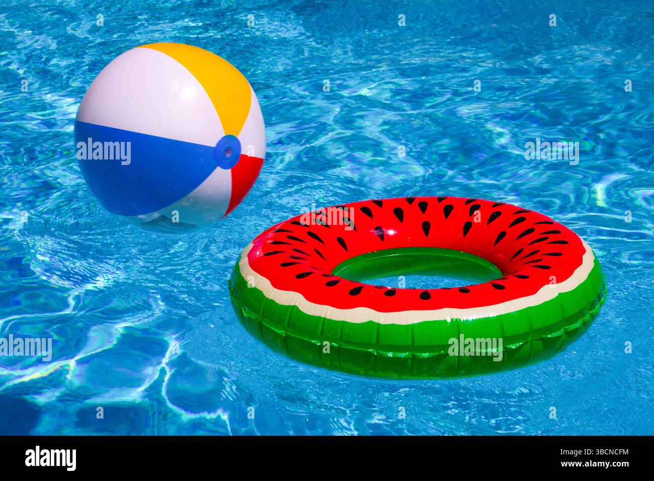 Summer day by the pool. Floating beach ball on pool water. Summer ...