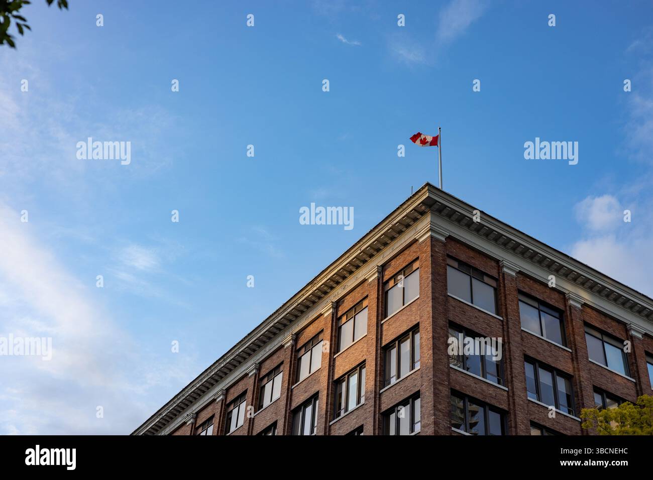 Canada flag on top of a classic building seen from below Stock Photo ...