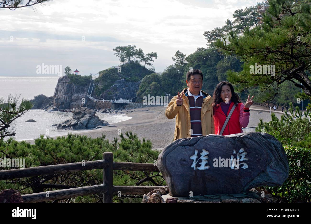 Japanese middle-aged couple tourists standing by a Katsurahama stone ...
