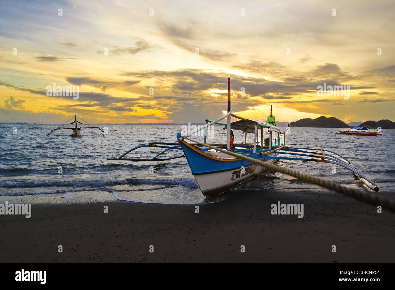 Fishing boats by the shore at sunset in Paniman Island, Caramoan ...