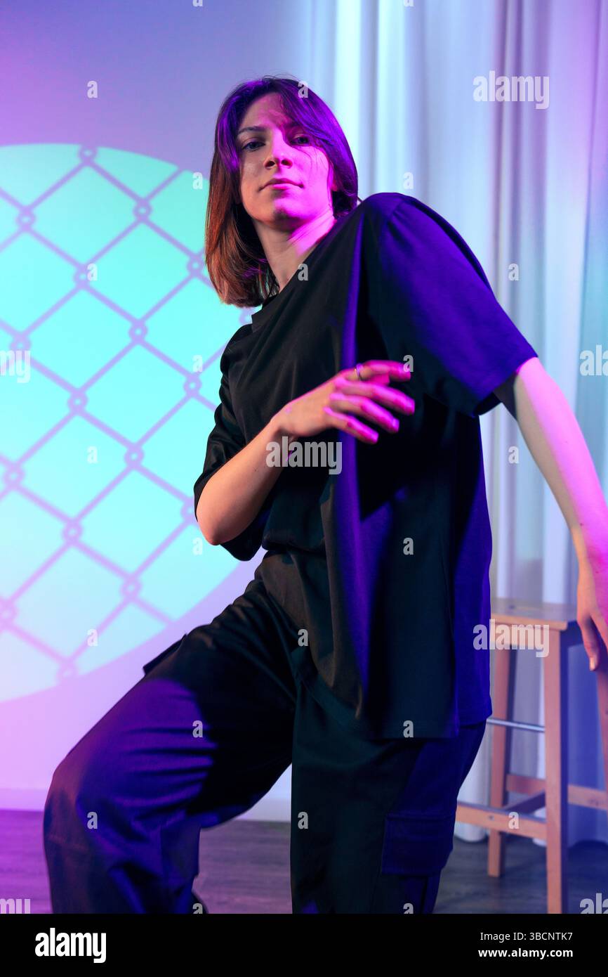 Performing artist dances gracefully under vibrant stage lights in a ...