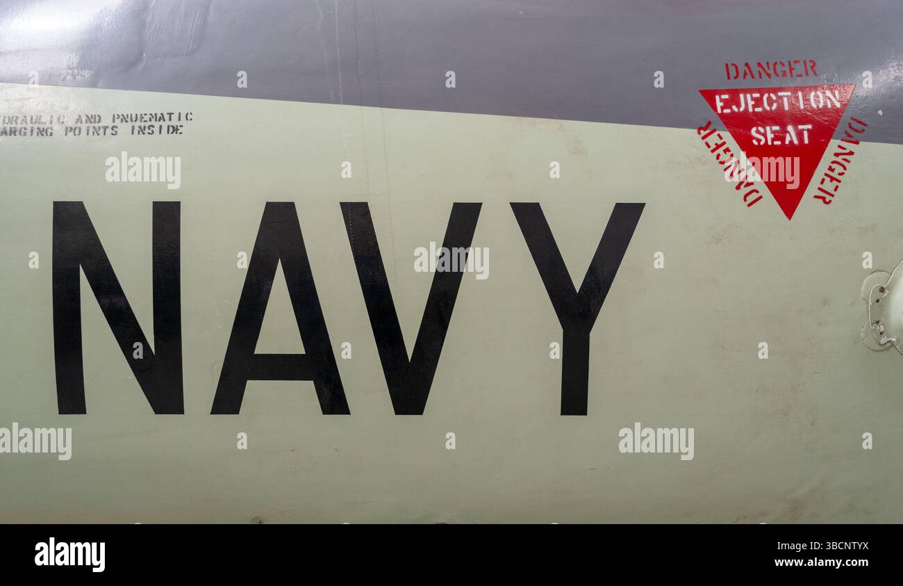 A close-up of an old aircraft fuselage displaying -NAVY- in bold black ...