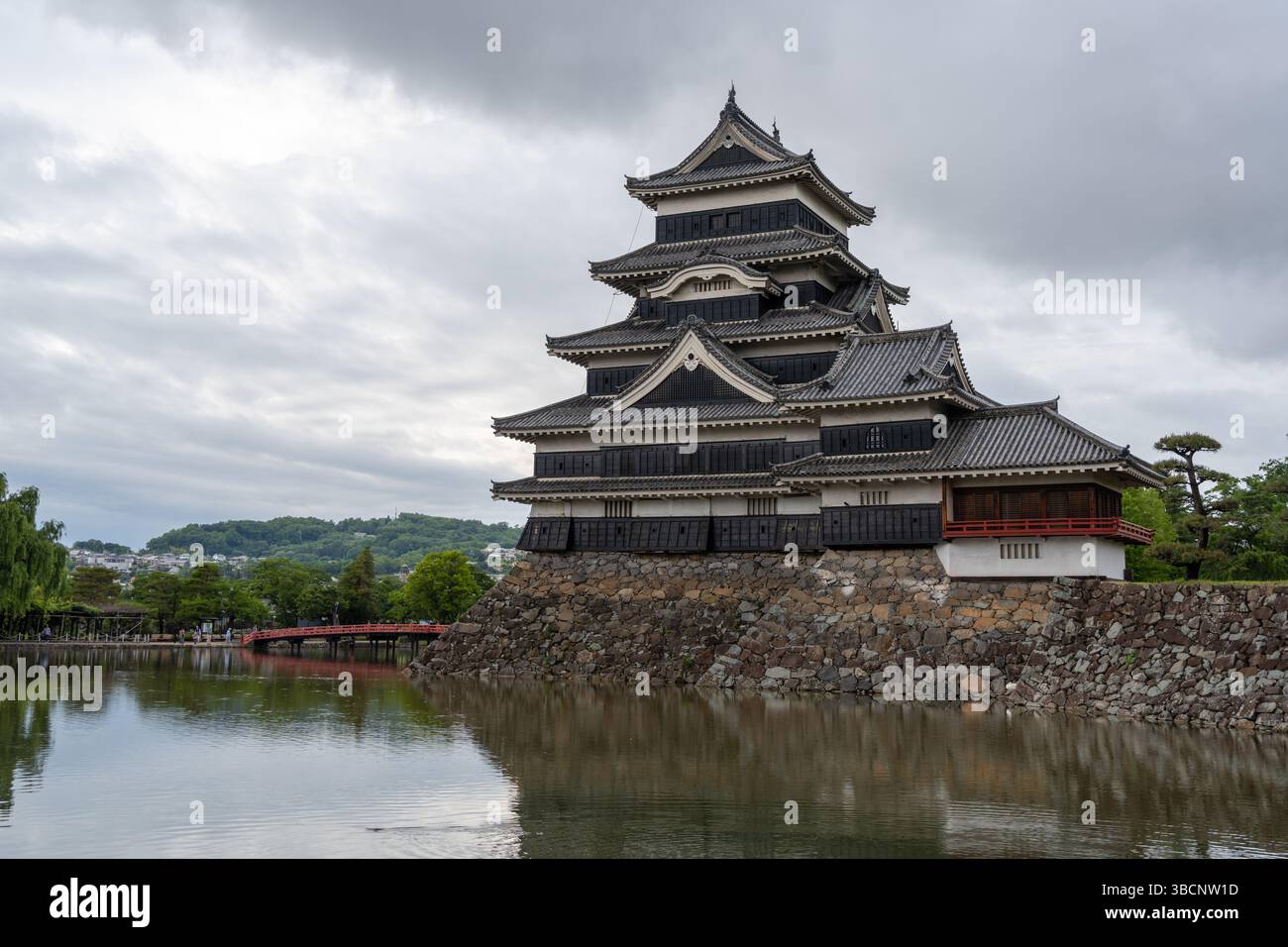 Matsumoto Castle stands majestically above its moat, surrounded by lush ...