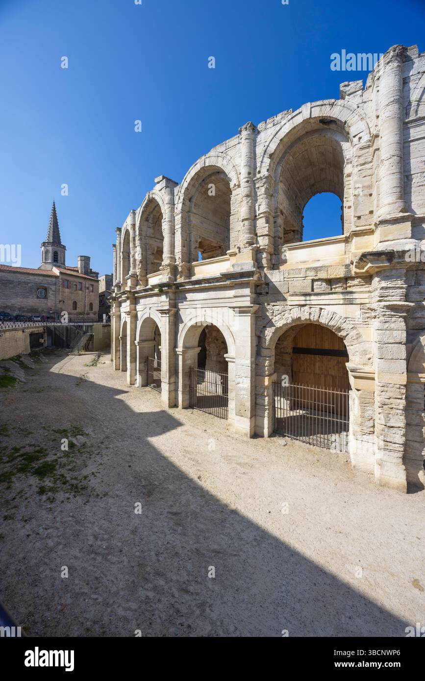 Roman amphitheatre in Arles, France, showing arches and ancient architecture on a sunny day ...