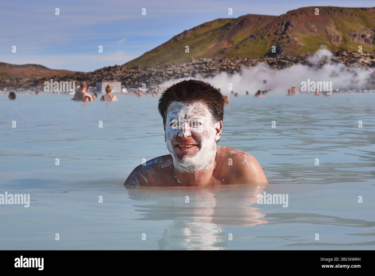 Man enjoying blue lagoon geothermal waters. Iceland attraction landmark ...