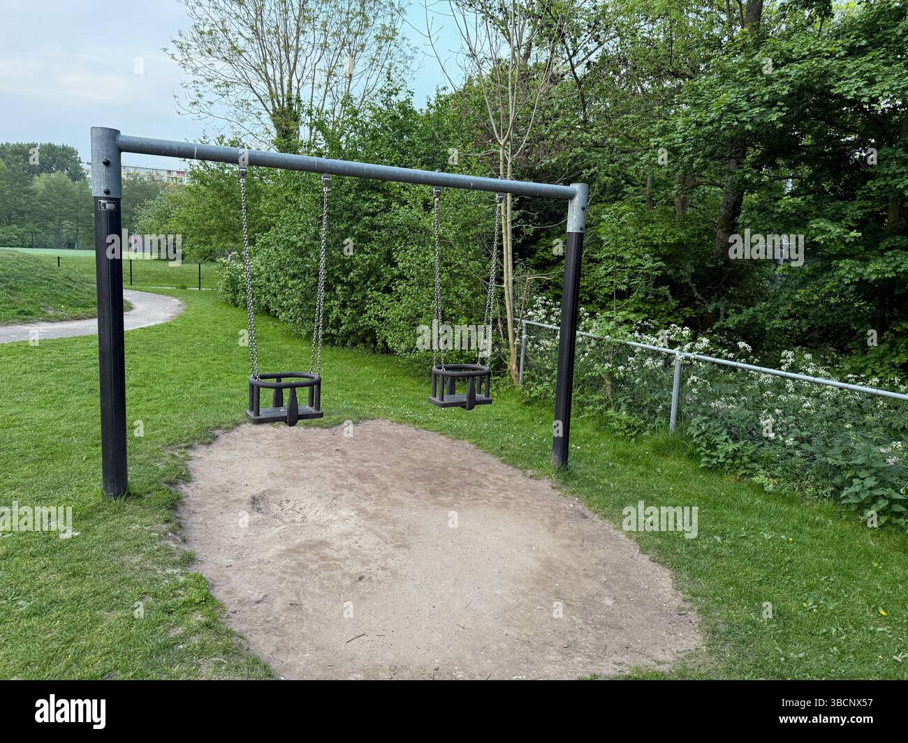 Empty swing set on playground in park Stock Photo - Alamy