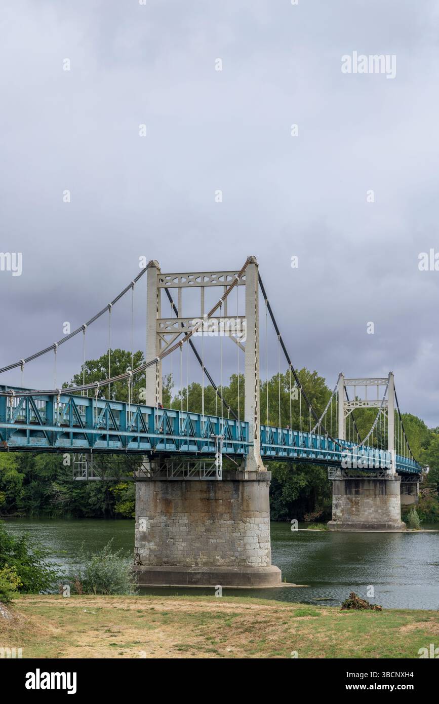 Metal suspension bridge with turquoise deck crossing the Garonne river ...