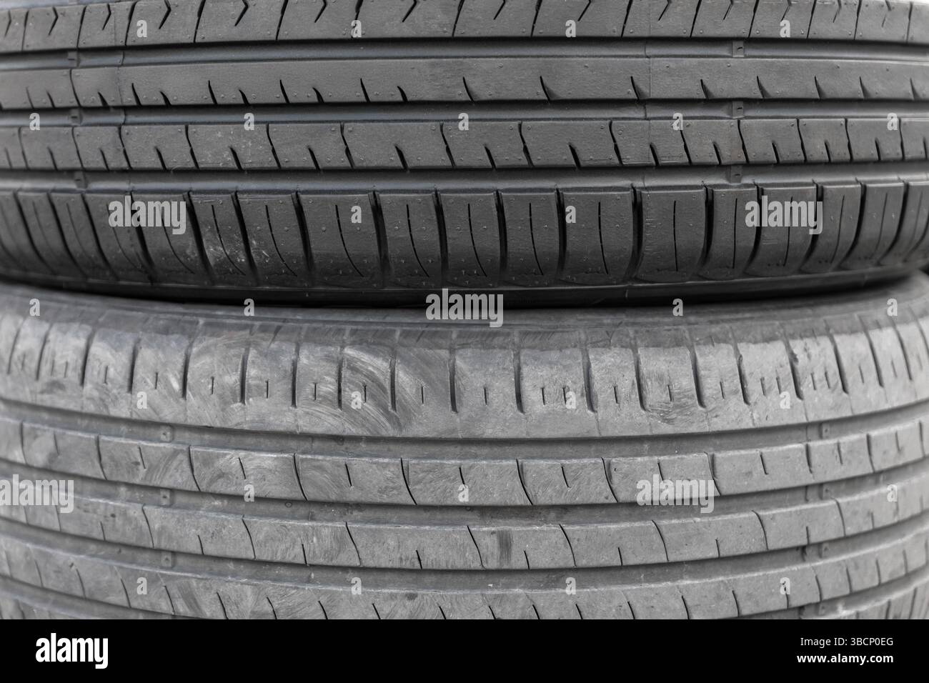 Side-by-side comparison of a new black tire and a worn-out gray tire ...