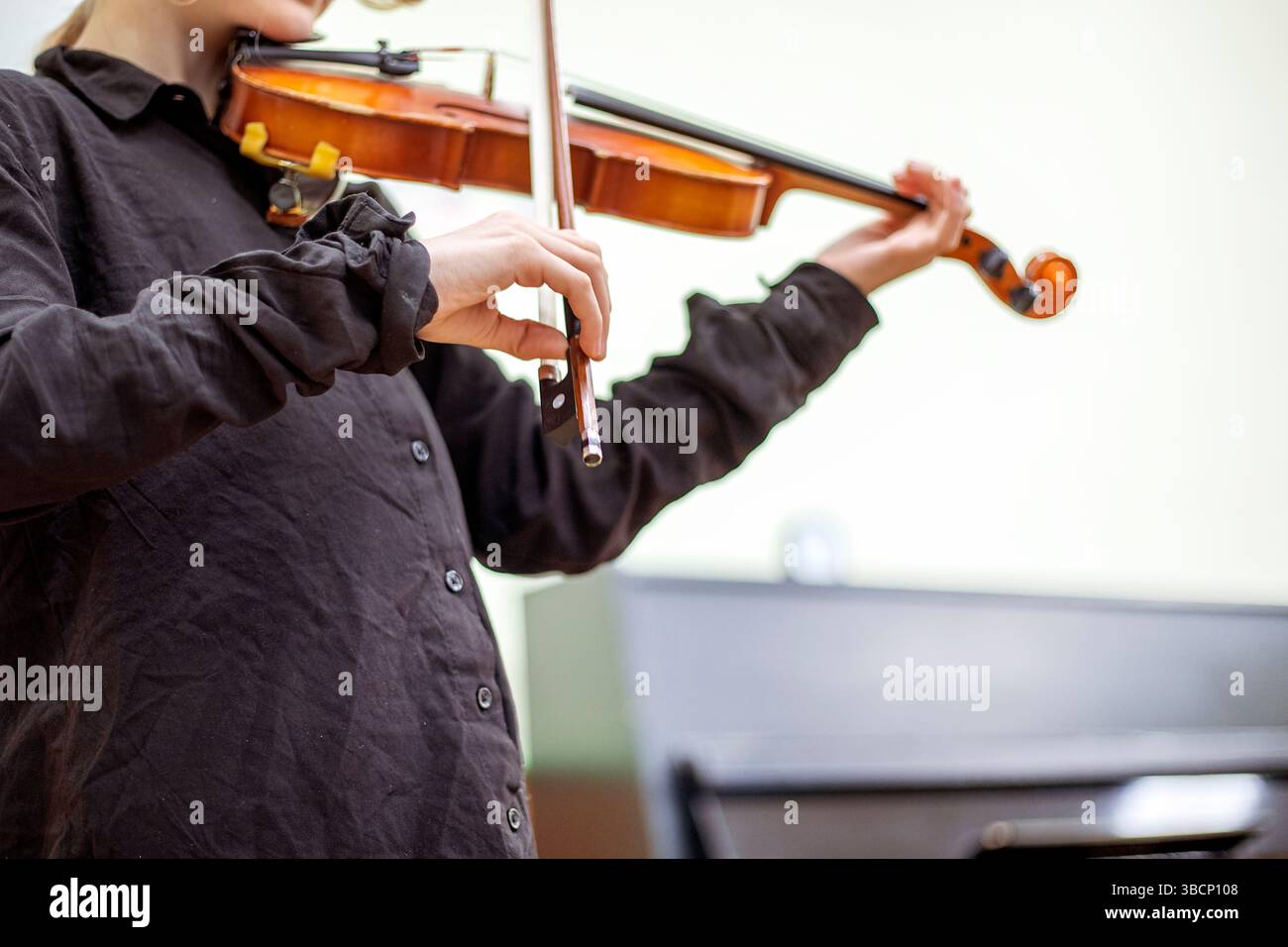 hand of a young violinist holding a bow while playing the violin ...