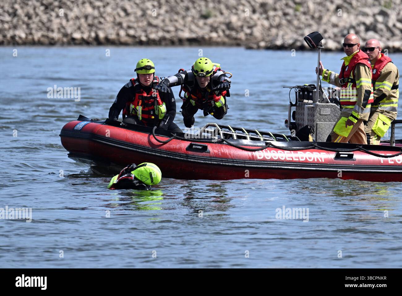 Duesseldorf, Germany. 21st May, 2025. A firefighter jumps from a boat ...