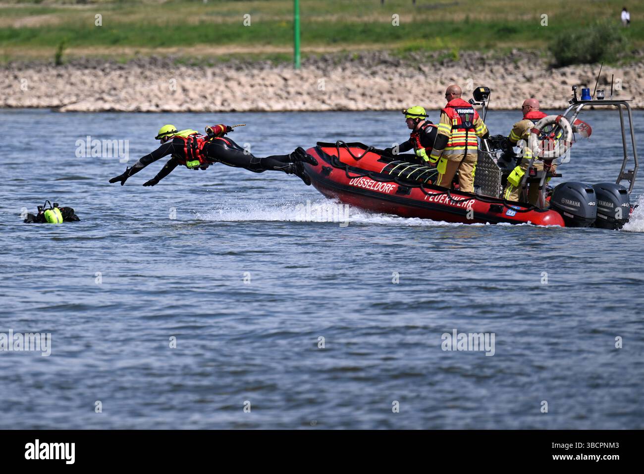 Duesseldorf, Germany. 21st May, 2025. A firefighter jumps from a boat ...