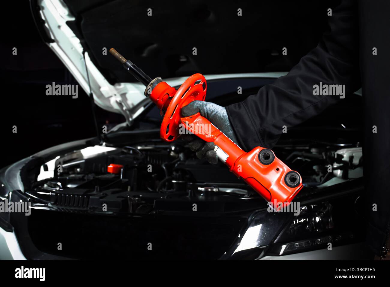 Car Shock Absorber, Mechanic holding a red shock absorber strut for a ...