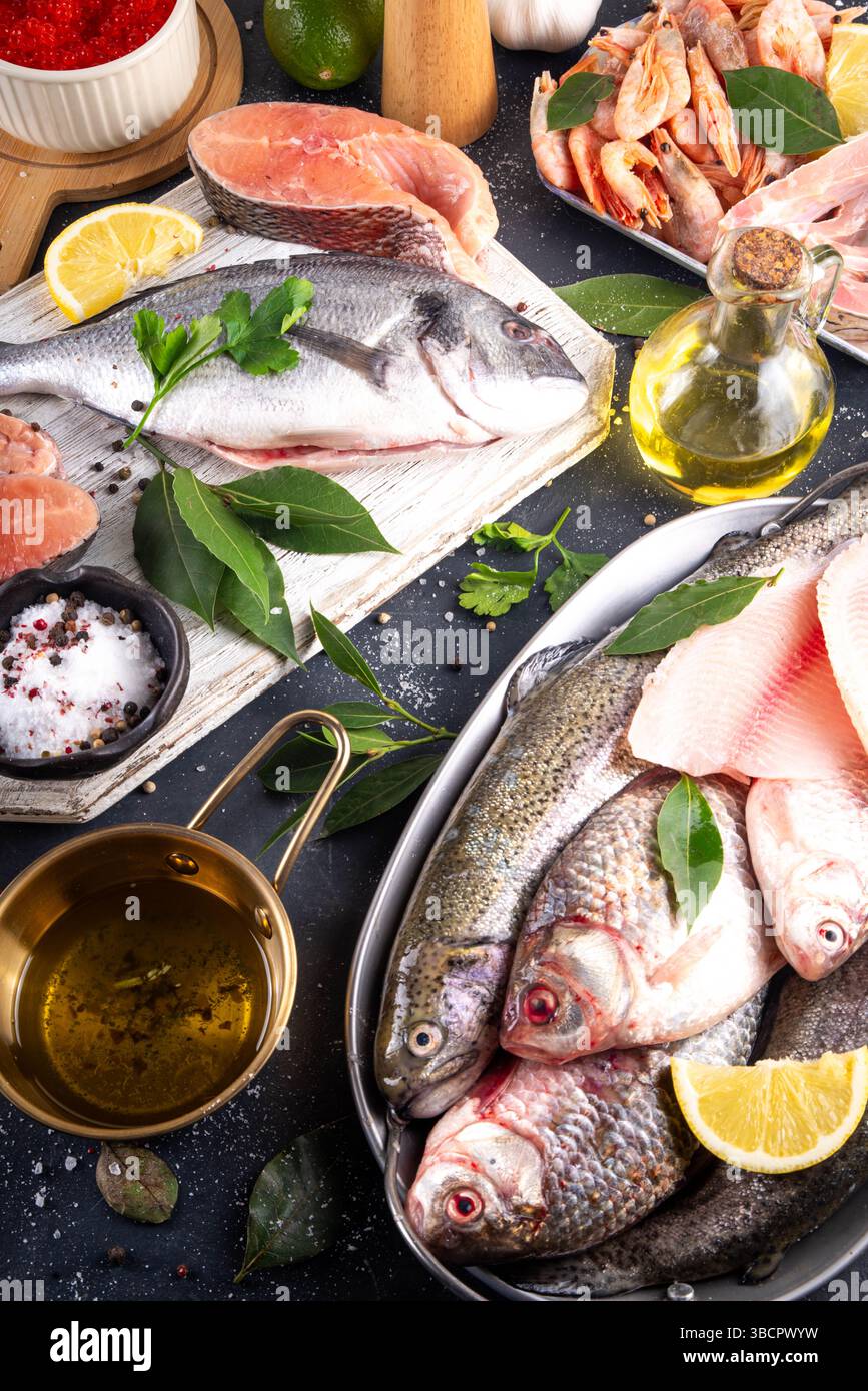 Variety raw fish and seafood background. Fresh fish, shrimps, mussels, caviar assortment flat ...