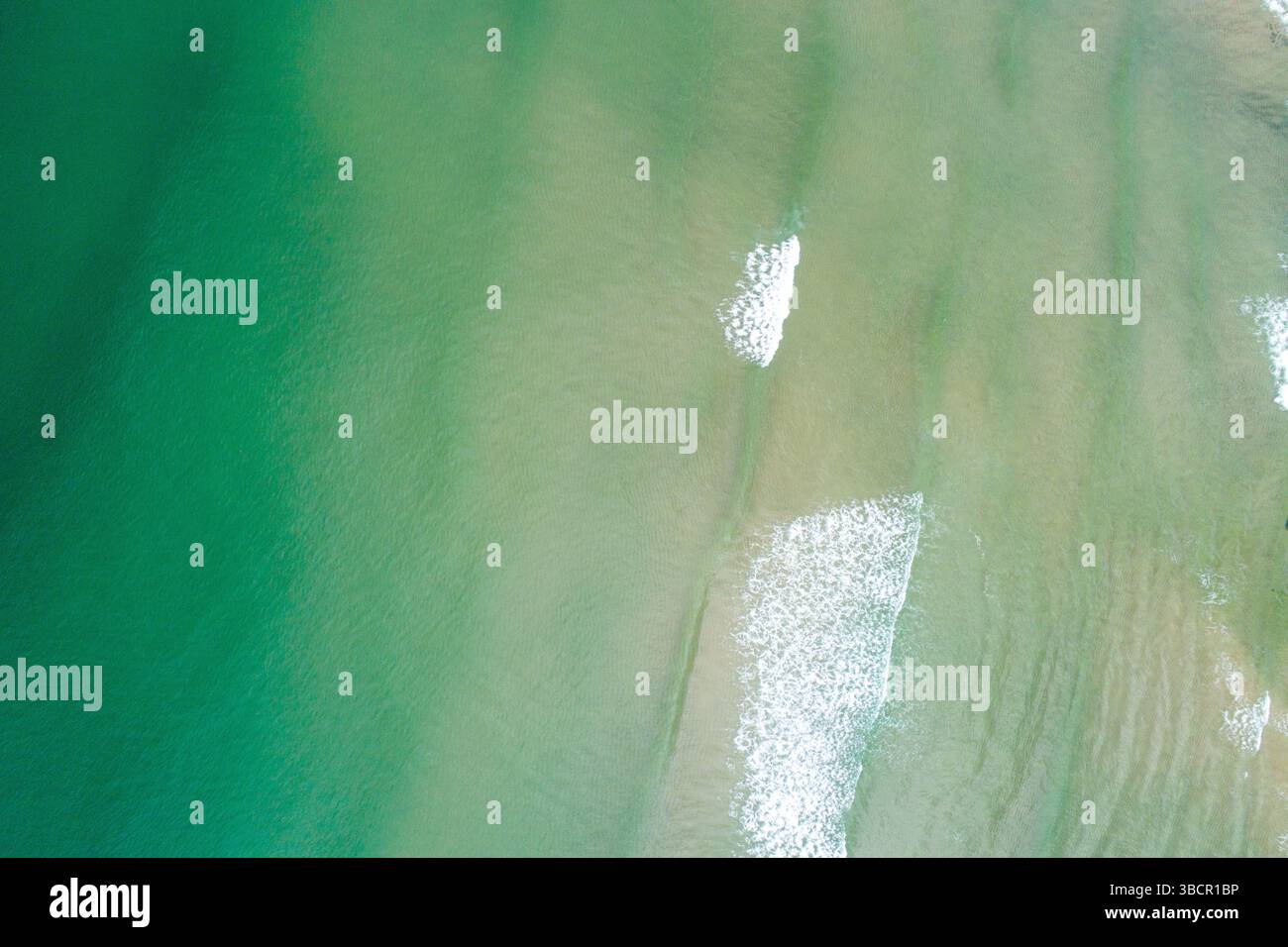 aerial perspective of a dynamic breaking wave with foam, top down view ...