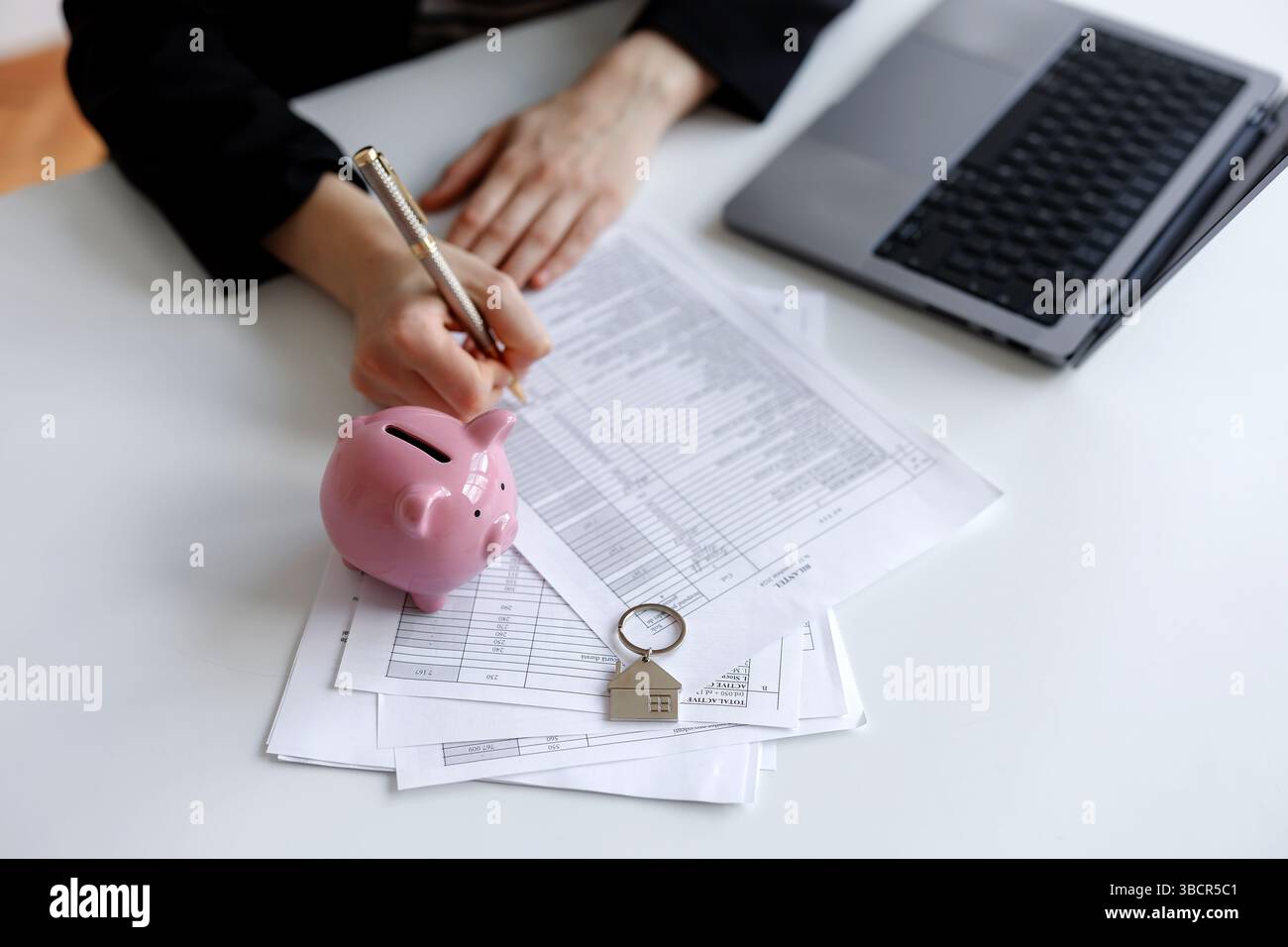 Individual reviews financial documents and plans budgeting with a pink ...