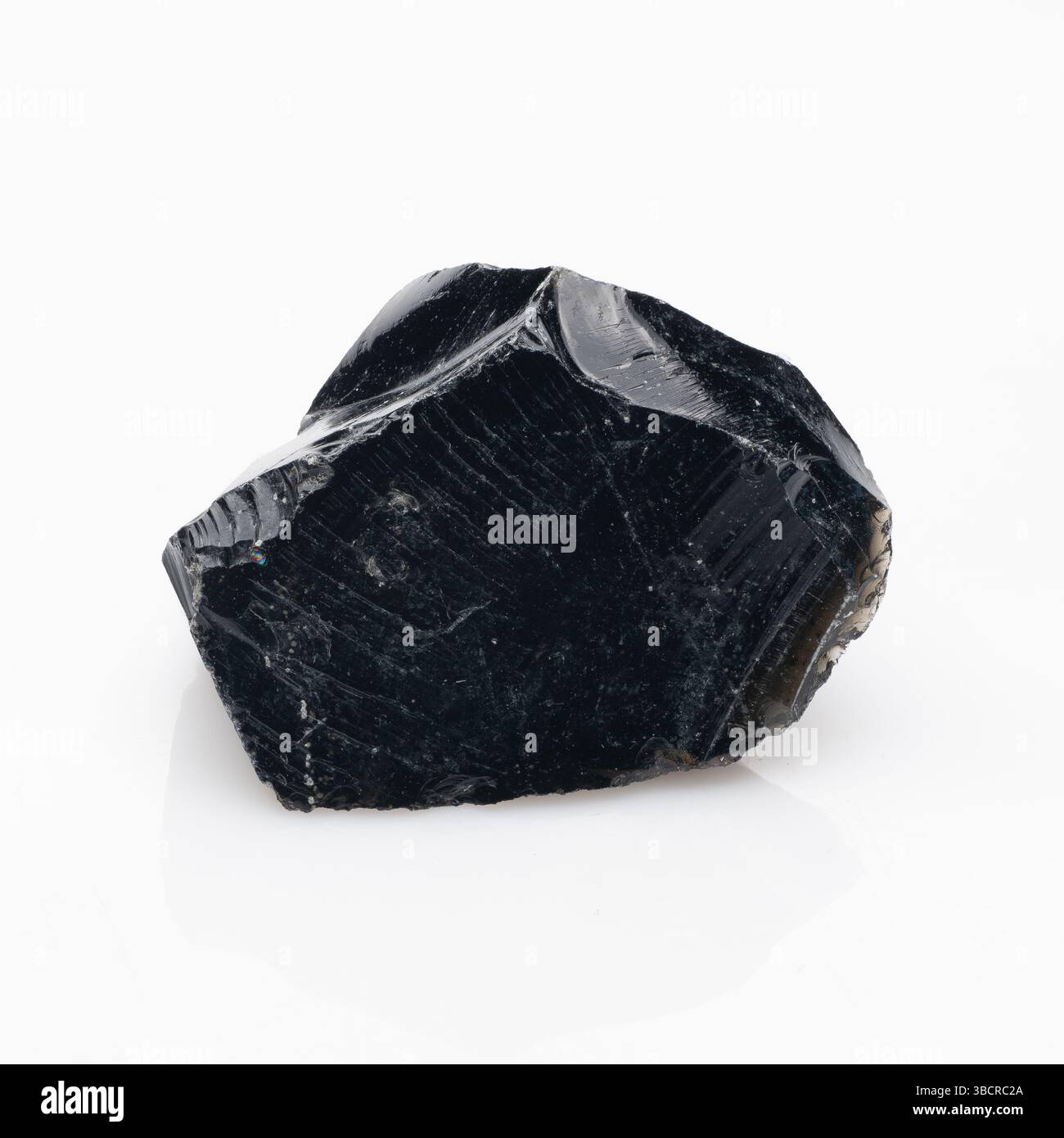 A striking, raw piece of natural black obsidian rock exhibiting a ...