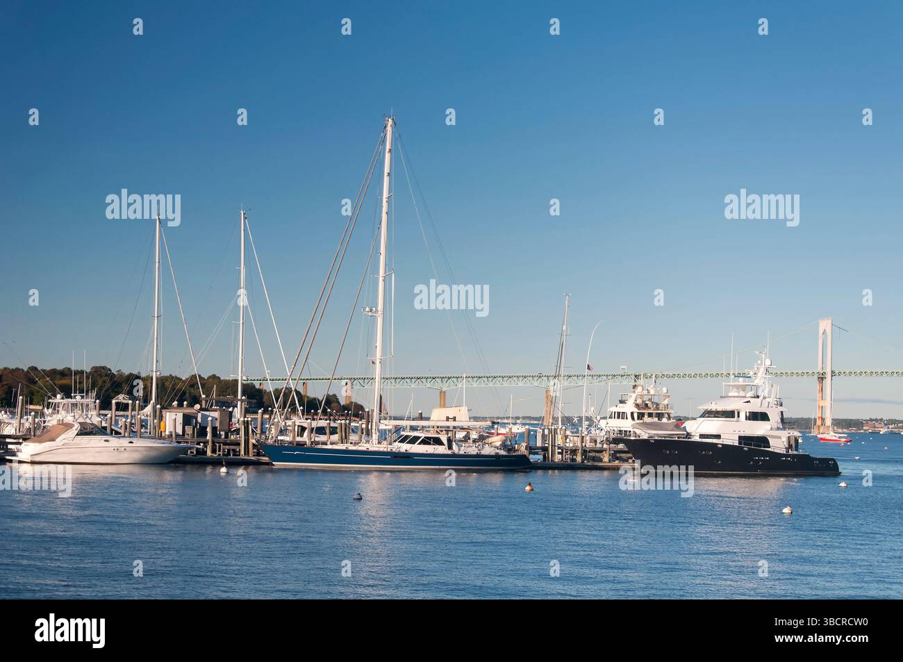 Boats moored in a harbor in front of the Claiborne Pell Newport bridge ...