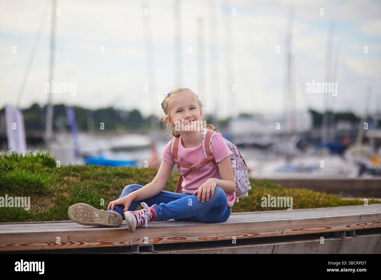 Adorable preschooler girl drawing on pebbles with bright acrylic paint ...