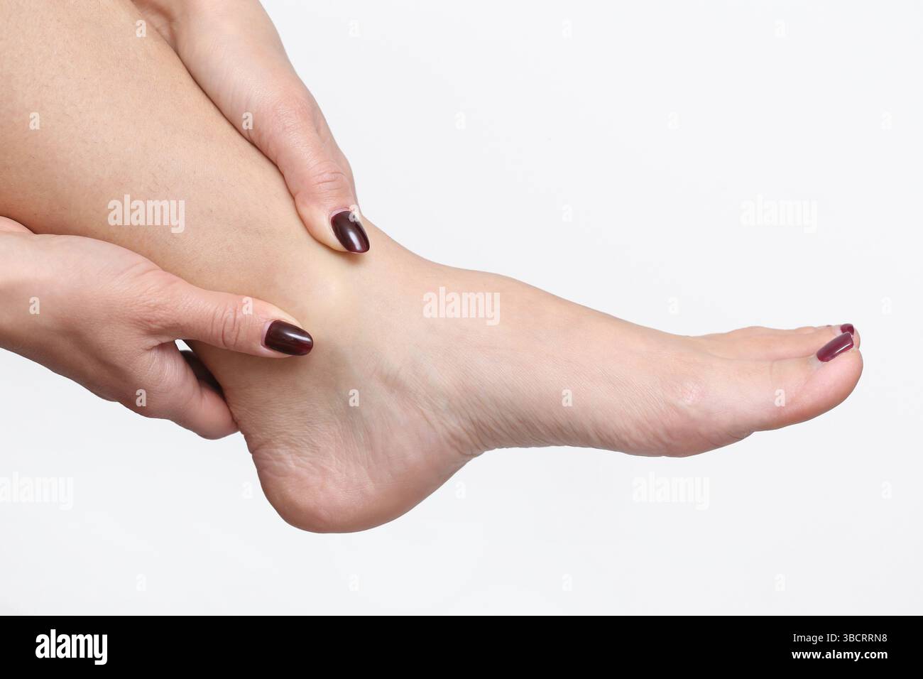 Woman holding sore foot. Pain in ankle area. Female touching leg gently ...