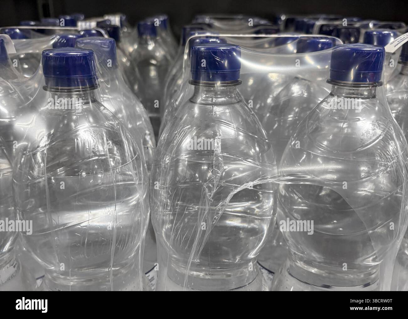 Clear plastic water bottles are neatly arranged in packaging ...