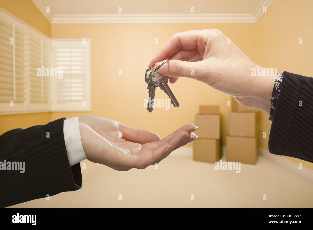 Woman handing over the house keys to A new home inside empty room Stock ...