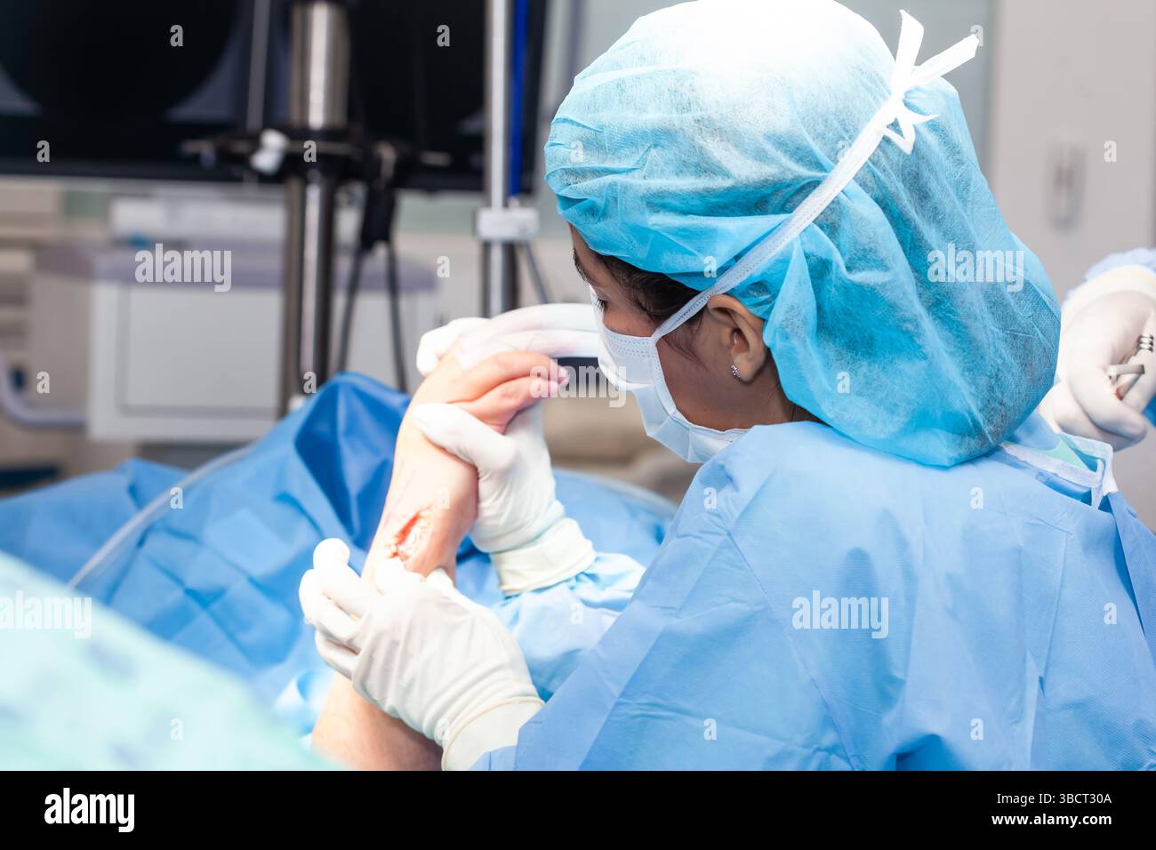 Female doctor performing a surgery. Orthopedic surgeon. Surgery and ...