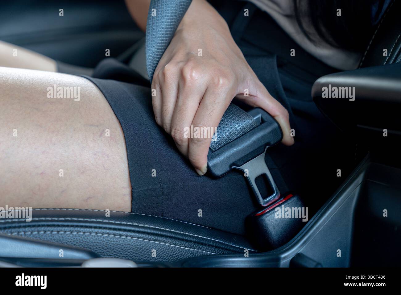 Putting safety first, a woman secures her seatbelt before hitting the road Stock Photo - Alamy
