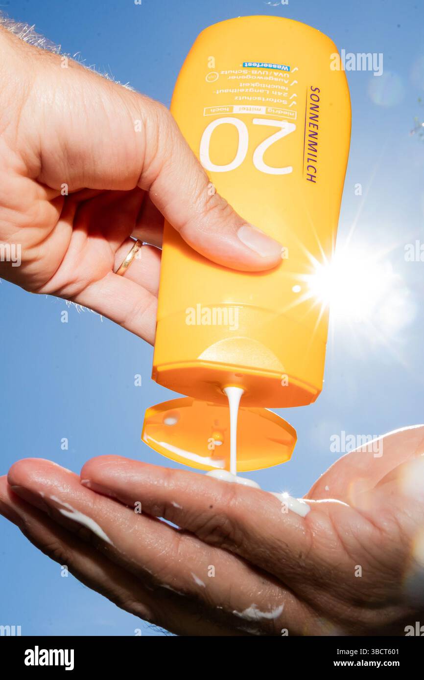 Berlin, Germany. 21st May, 2025. A man pours suntan lotion from a tube ...