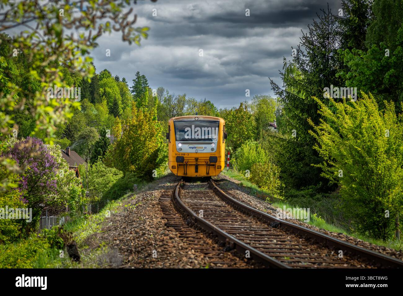 Yellow engine unit passenger train in fresh spring sunny day near ...