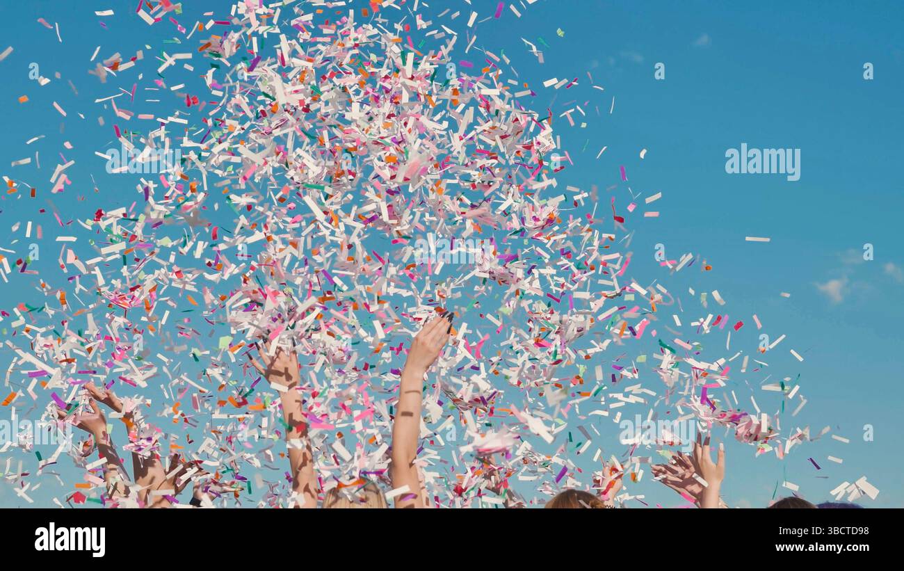 High school students joyfully celebrating graduation by tossing ...