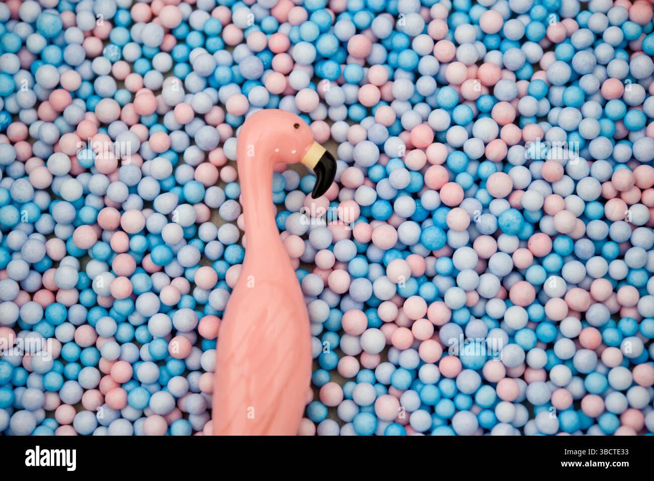 pink flamingo plastic toy over small pastel spheres Stock Photo - Alamy
