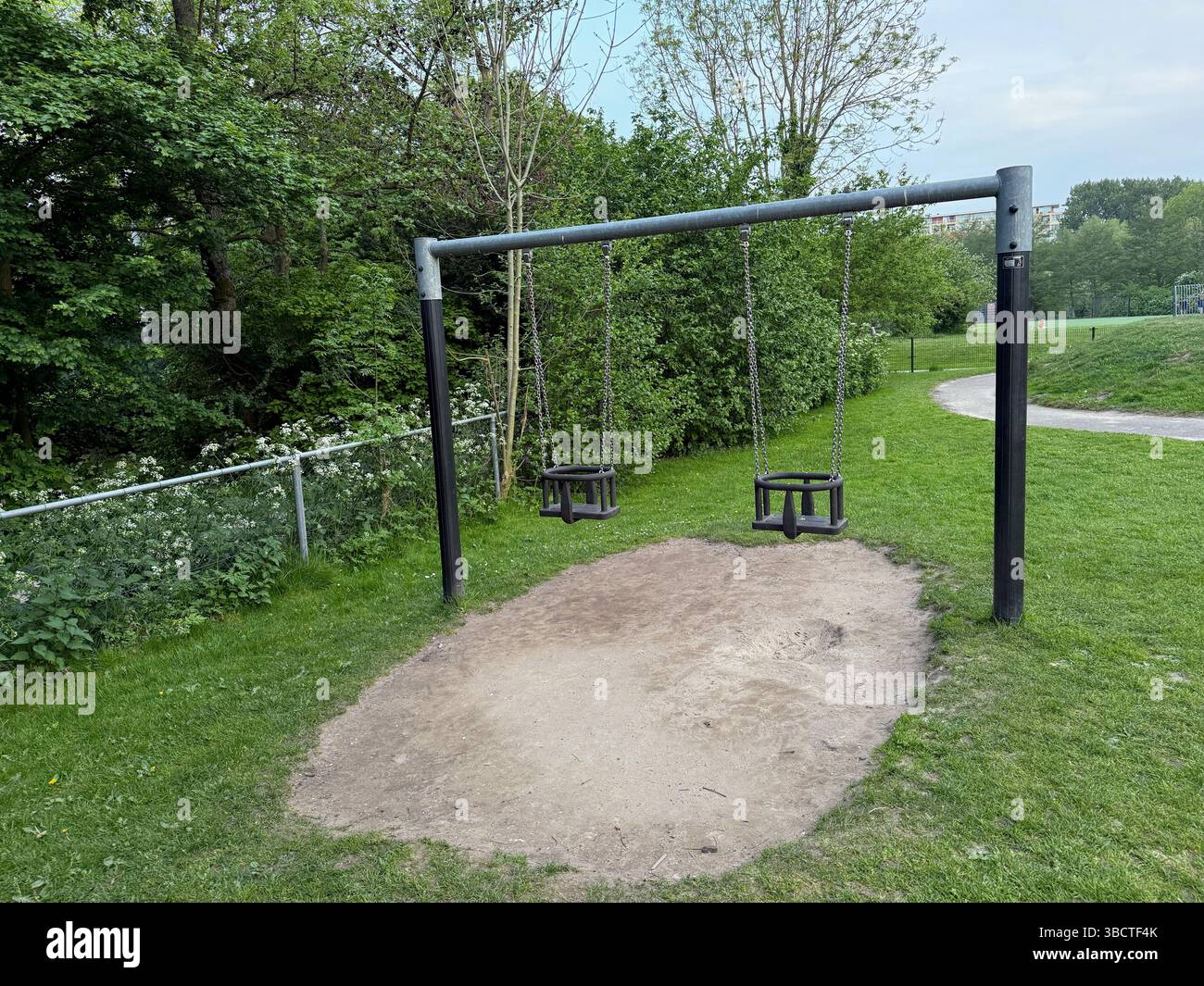 Empty swing set on playground in park Stock Photo - Alamy