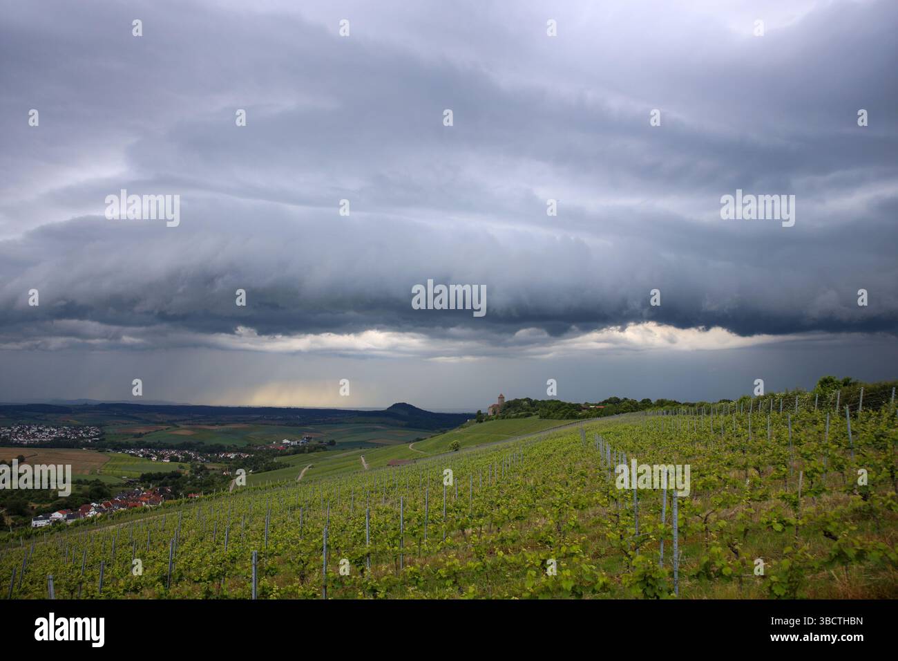 Oberstenfeld, Germany. 21st May, 2025. A dark thundercloud looms behind ...