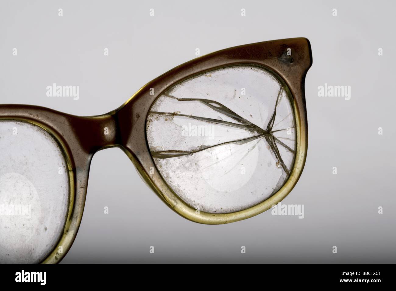 Pair of old glasses with a cracked lens Stock Photo - Alamy