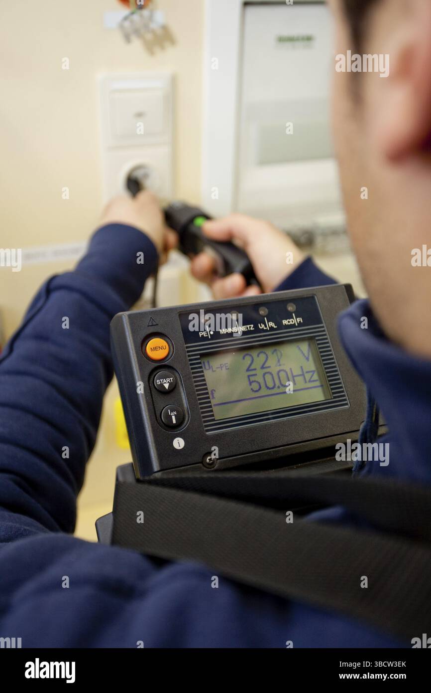 Master electrician student using a voltmeter on a VDE measuring station ...