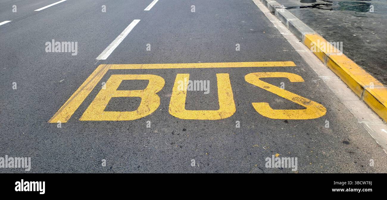 Yellow bus stop marking painted on asphalt road surface indicating ...