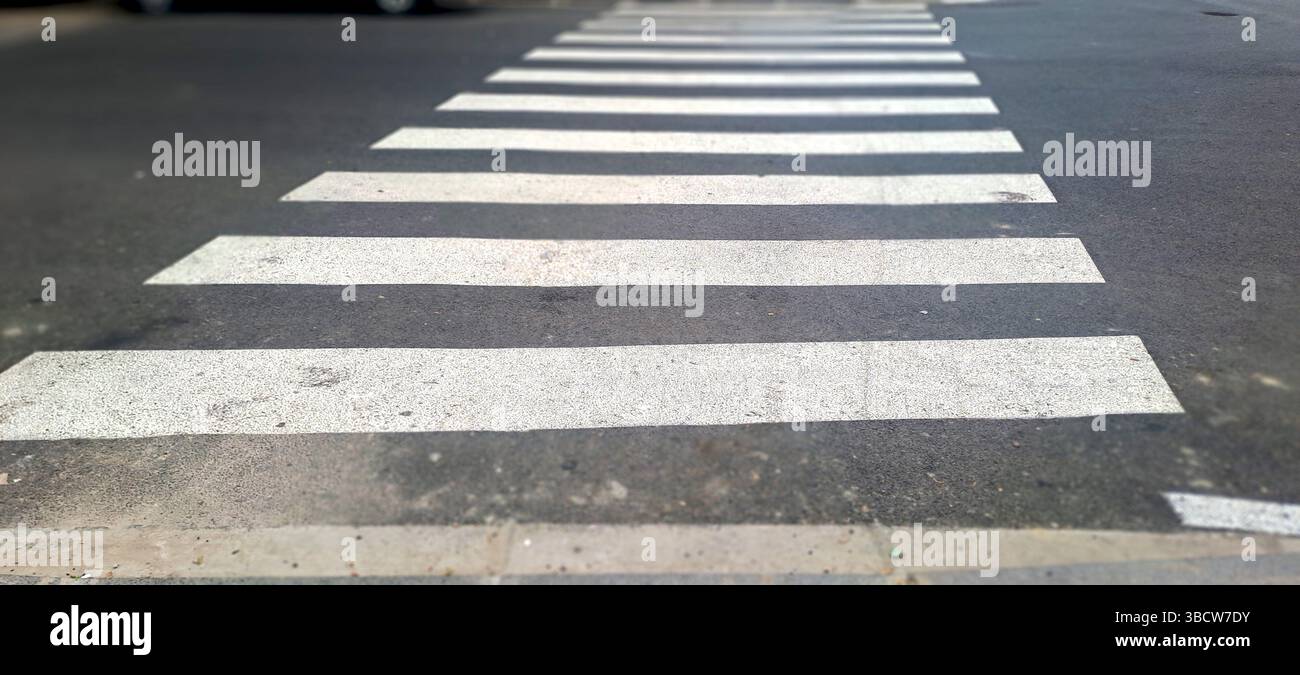 White painted pedestrian crossing on asphalt road ensuring safe passage ...