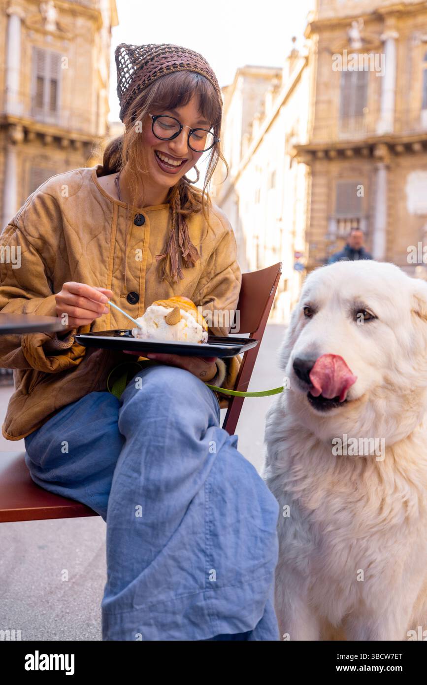 A woman shares a sweet moment with her dog while enjoying a traditional ...