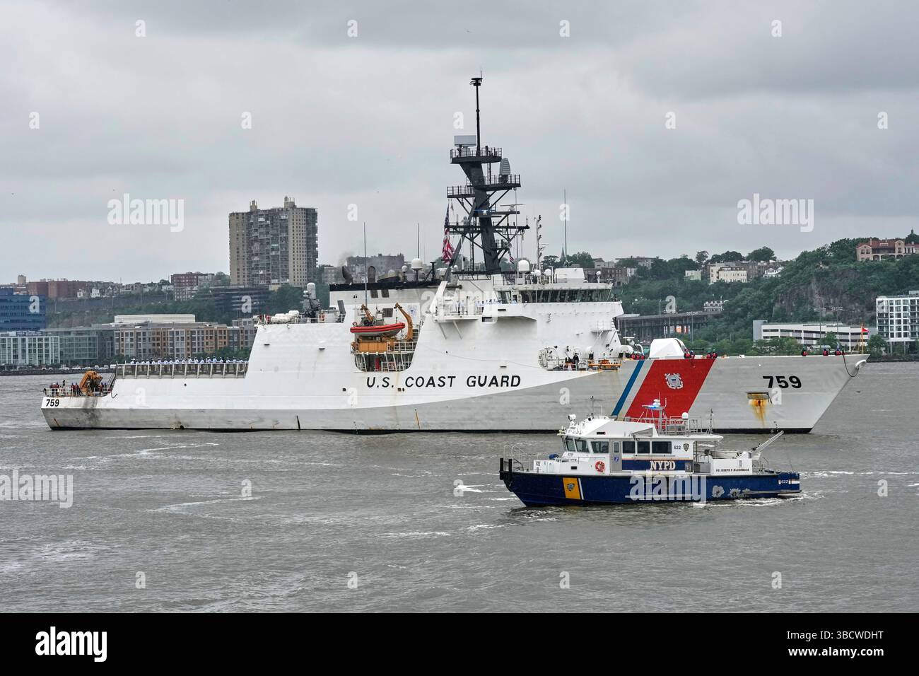A New York City Police Department boat, foreground, passes the US Coast ...
