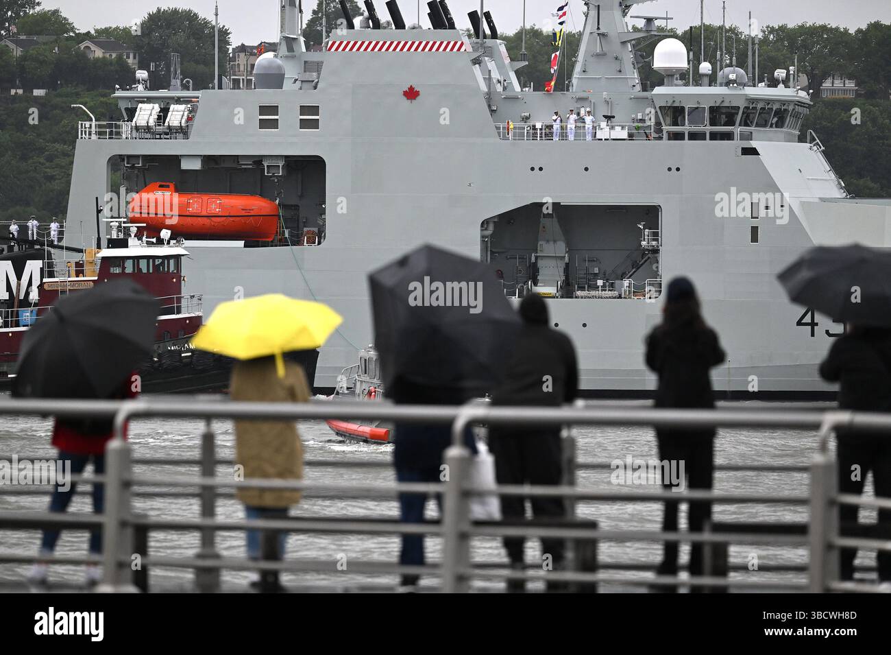 New York, USA. 21st May, 2025. People standing along Pier 84 watch as ...