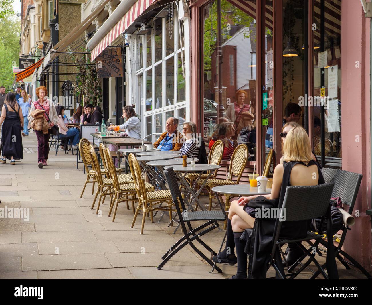 People eating outdoors at restaurant and cafe pavement tables on ...