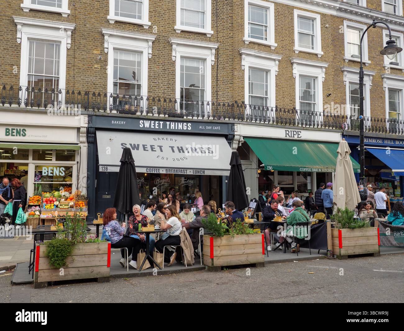 People eating outdoors at restaurant and cafe pavement tables in ...