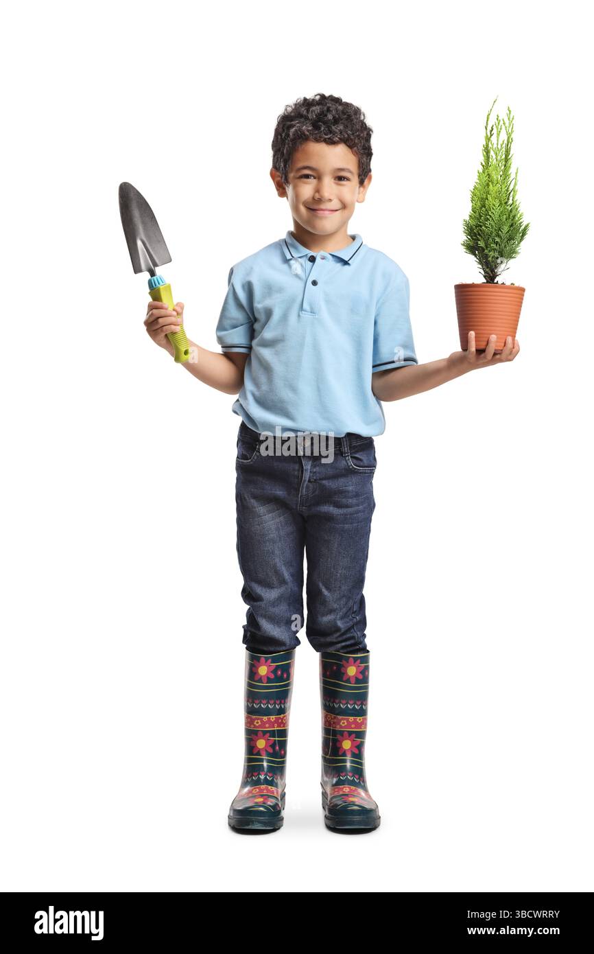 Asian boy holding a small tree in a pot and a spade isolated on white ...