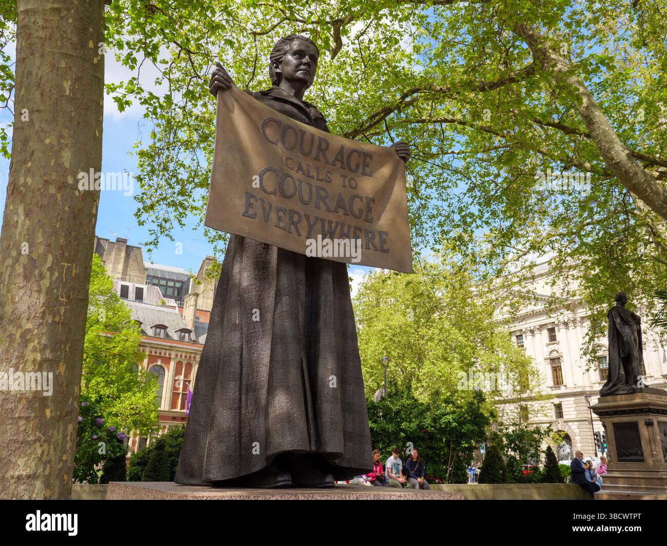 Statue of suffragete Millicent Fawcett holding banner saying "Courage ...