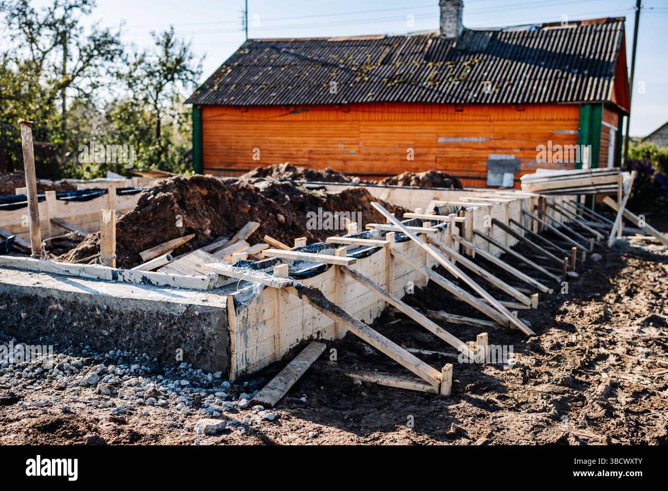 Building strip foundation for new house near old wooden house Stock ...
