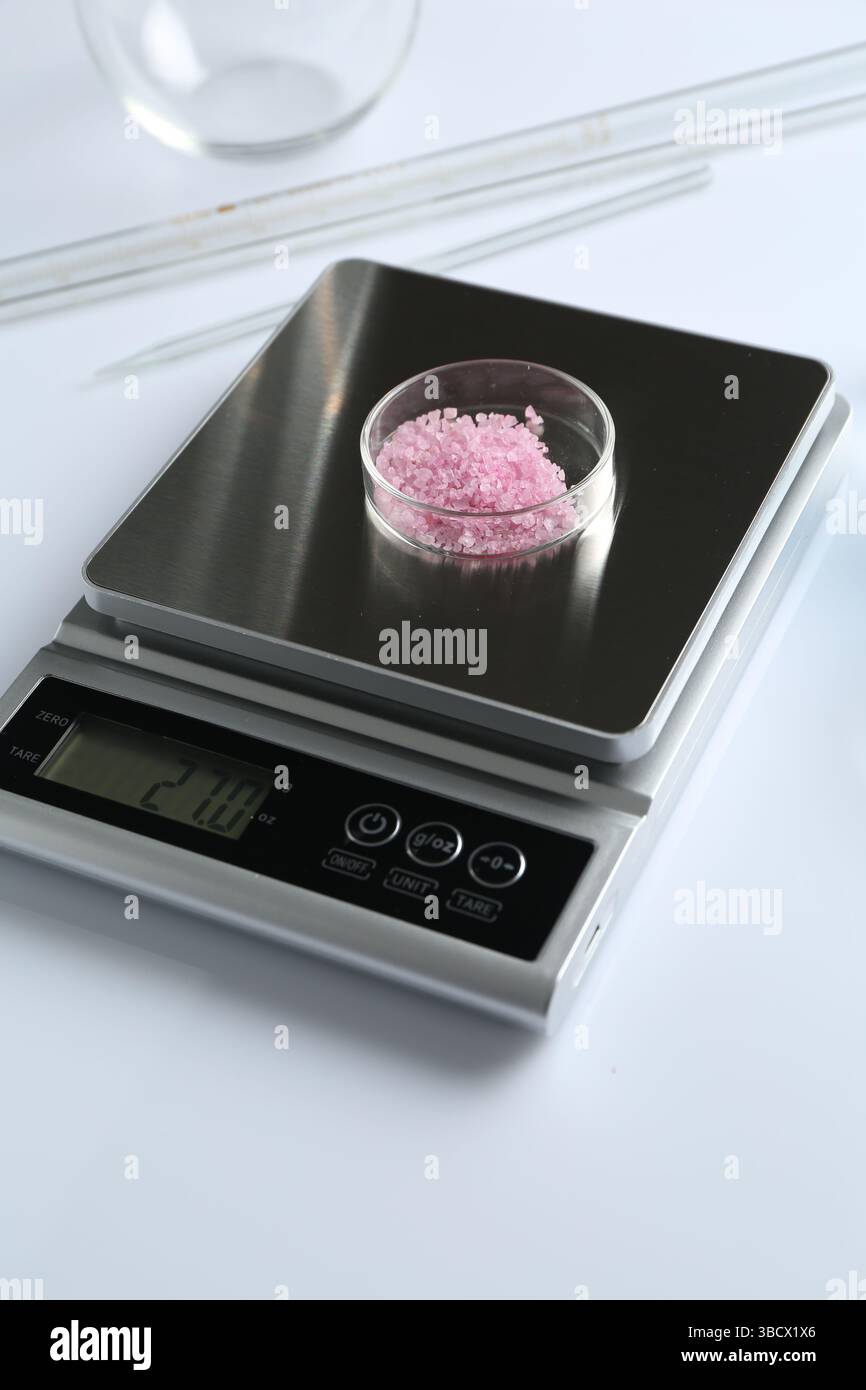Scale with Petri dish of sample and other laboratory equipment on white ...