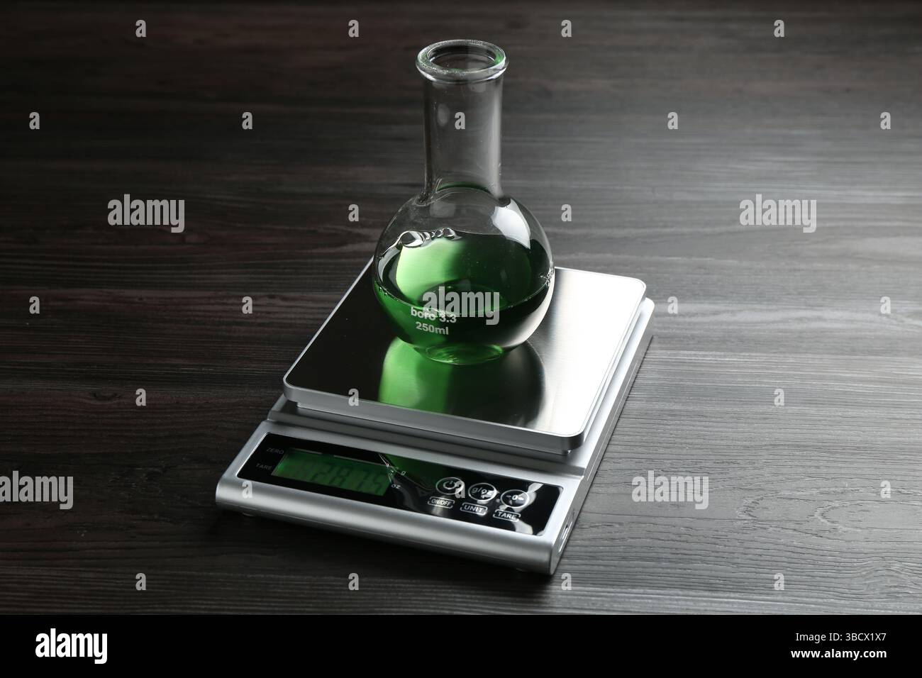 Laboratory scale with flask of sample on wooden table Stock Photo - Alamy