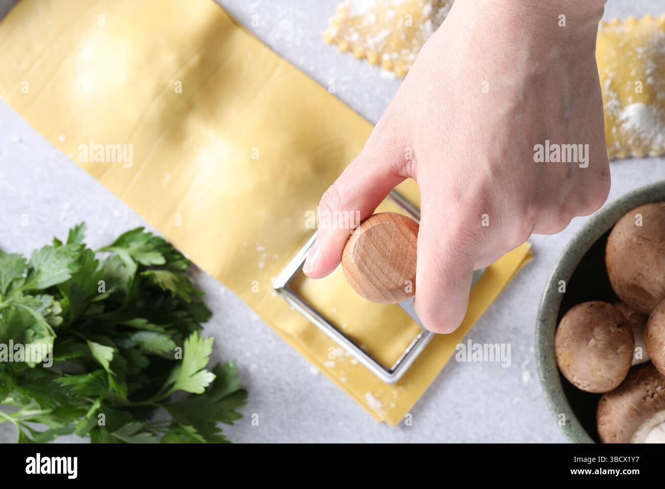 Woman cutting ravioli at light table, top view Stock Photo - Alamy