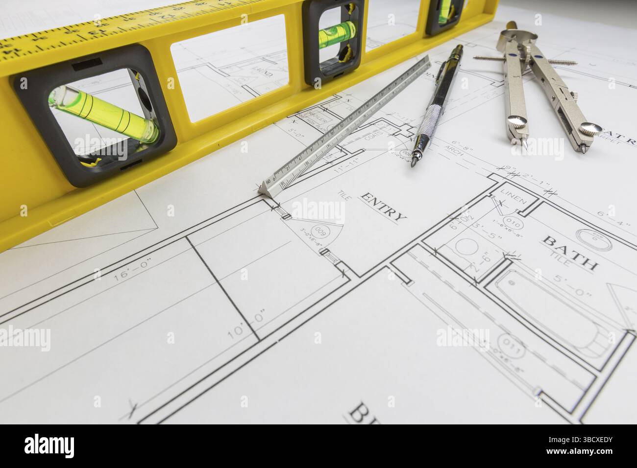 Construction level, engineer pencil, ruler and compass resting on ...